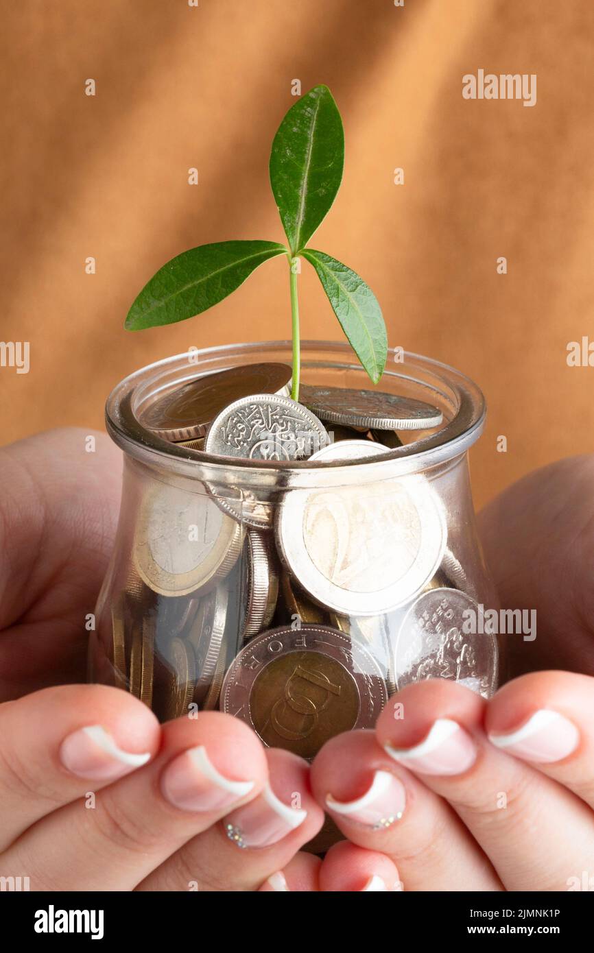 Person holding jar coins hands Stock Photo - Alamy