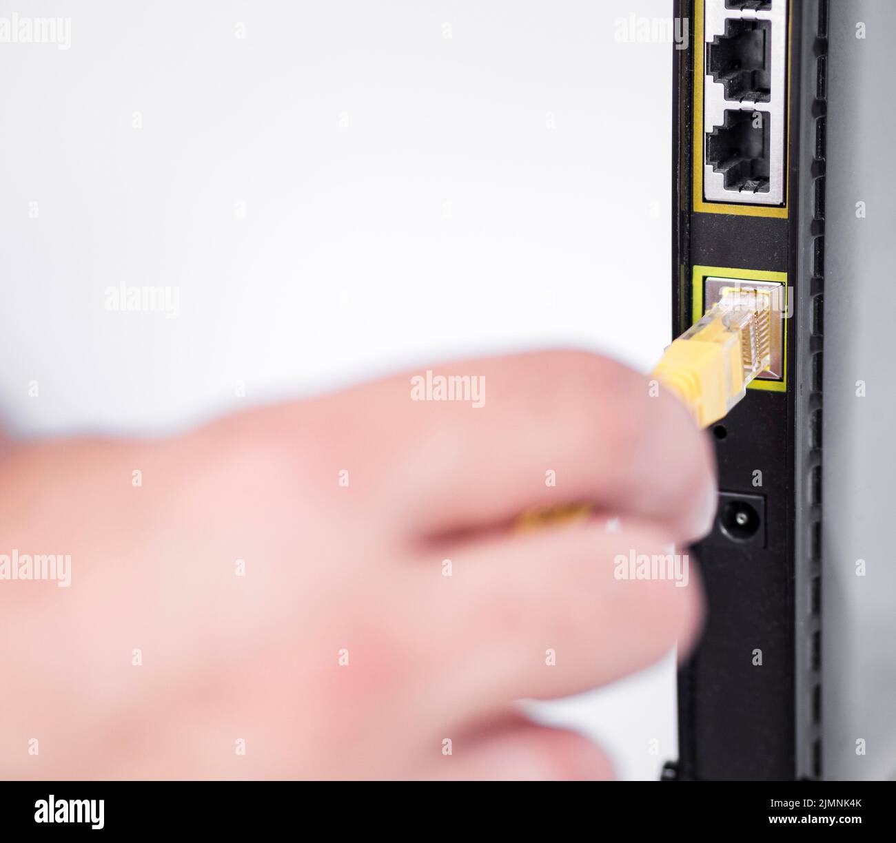 Hand plugging ethernet cable into router Stock Photo - Alamy