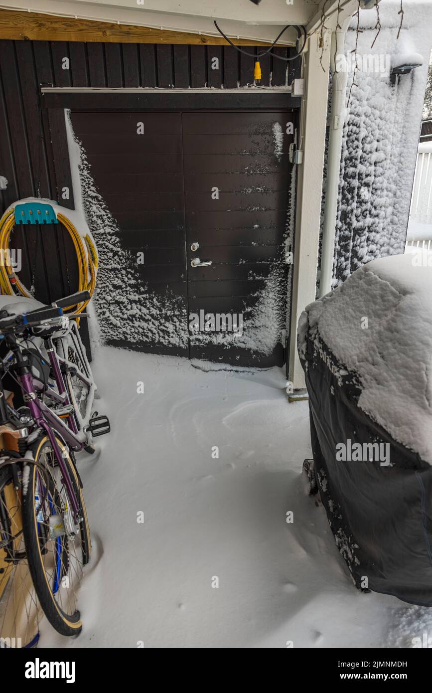 Beautiful view of back of snowy modern villa with bicycles and other ...
