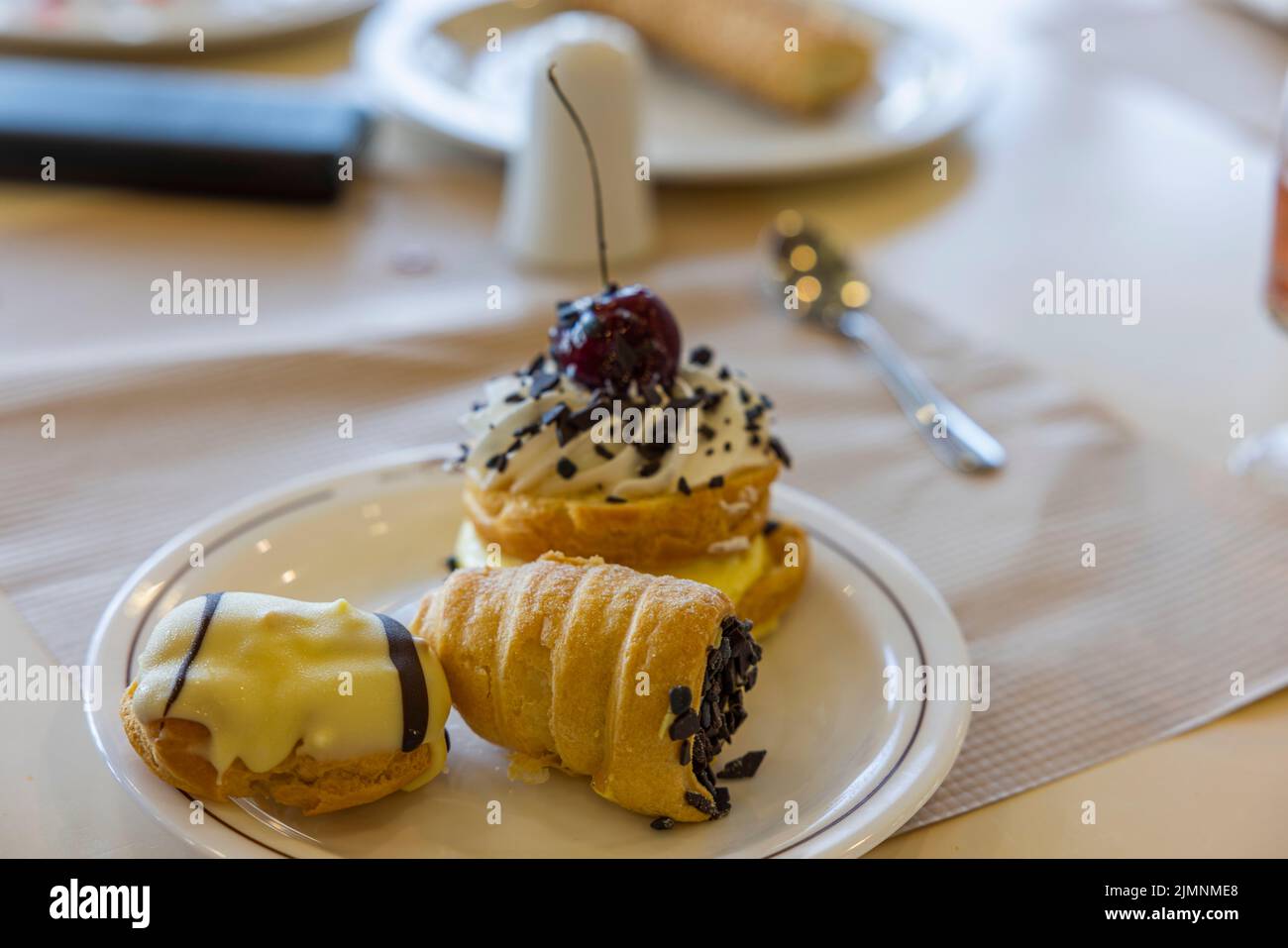Close up view of three small cakes on white plate Stock Photo - Alamy