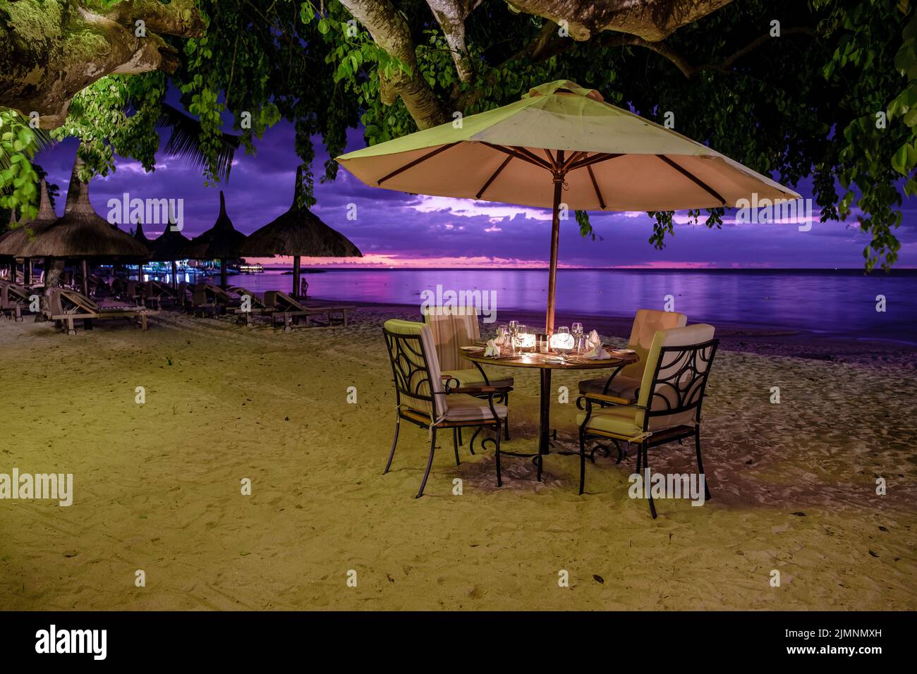 Sunset on the beach in Mauritius, luxury restaurant with umbrella and ...