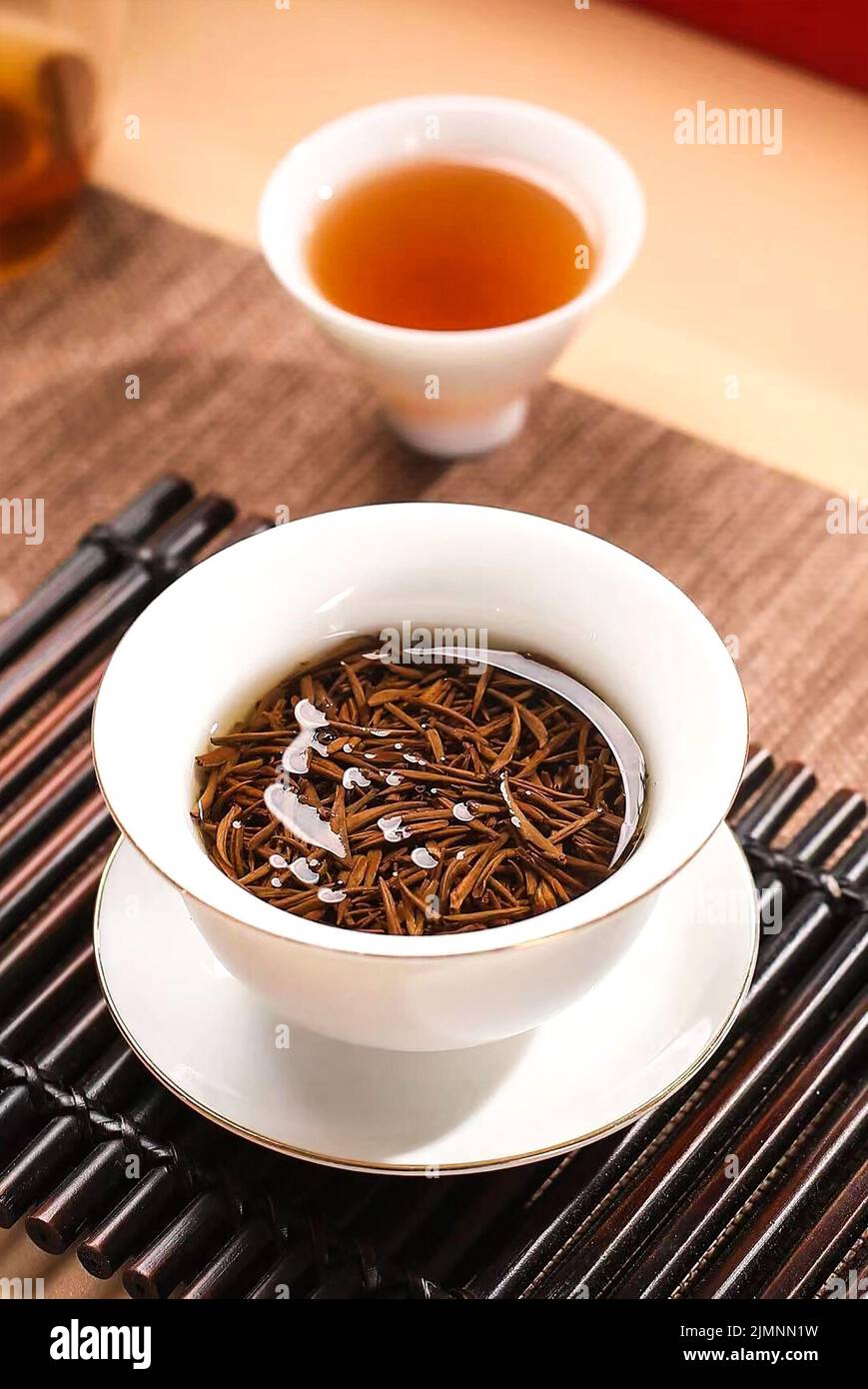 A vertical close-up shot of tea petals and water in a bowl Stock Photo ...