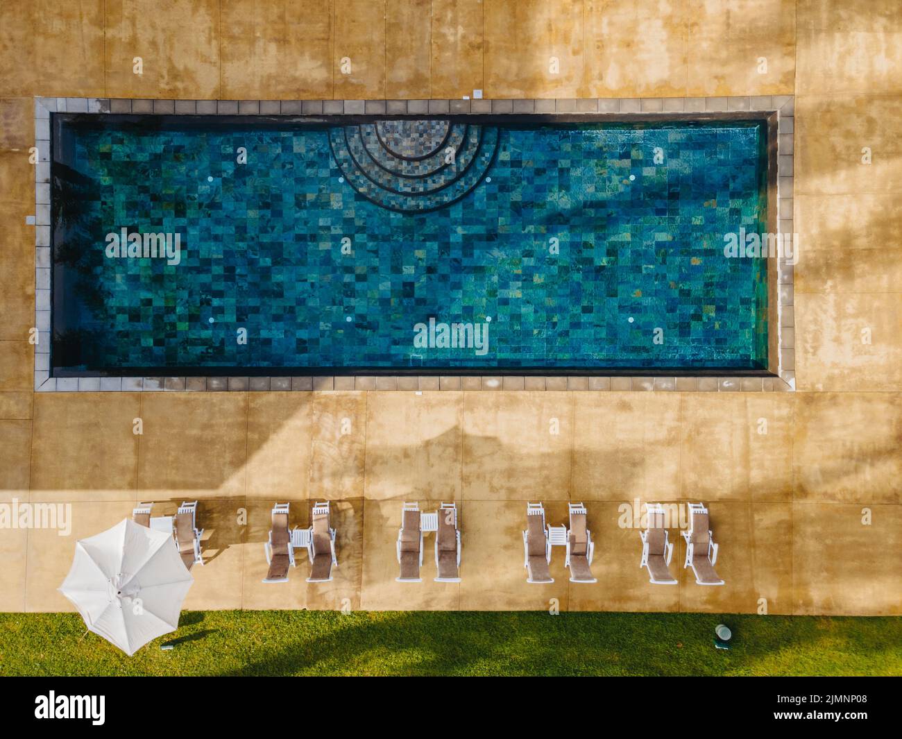 Swimming pool with beach chairs and lunch table at a luxury resort ...