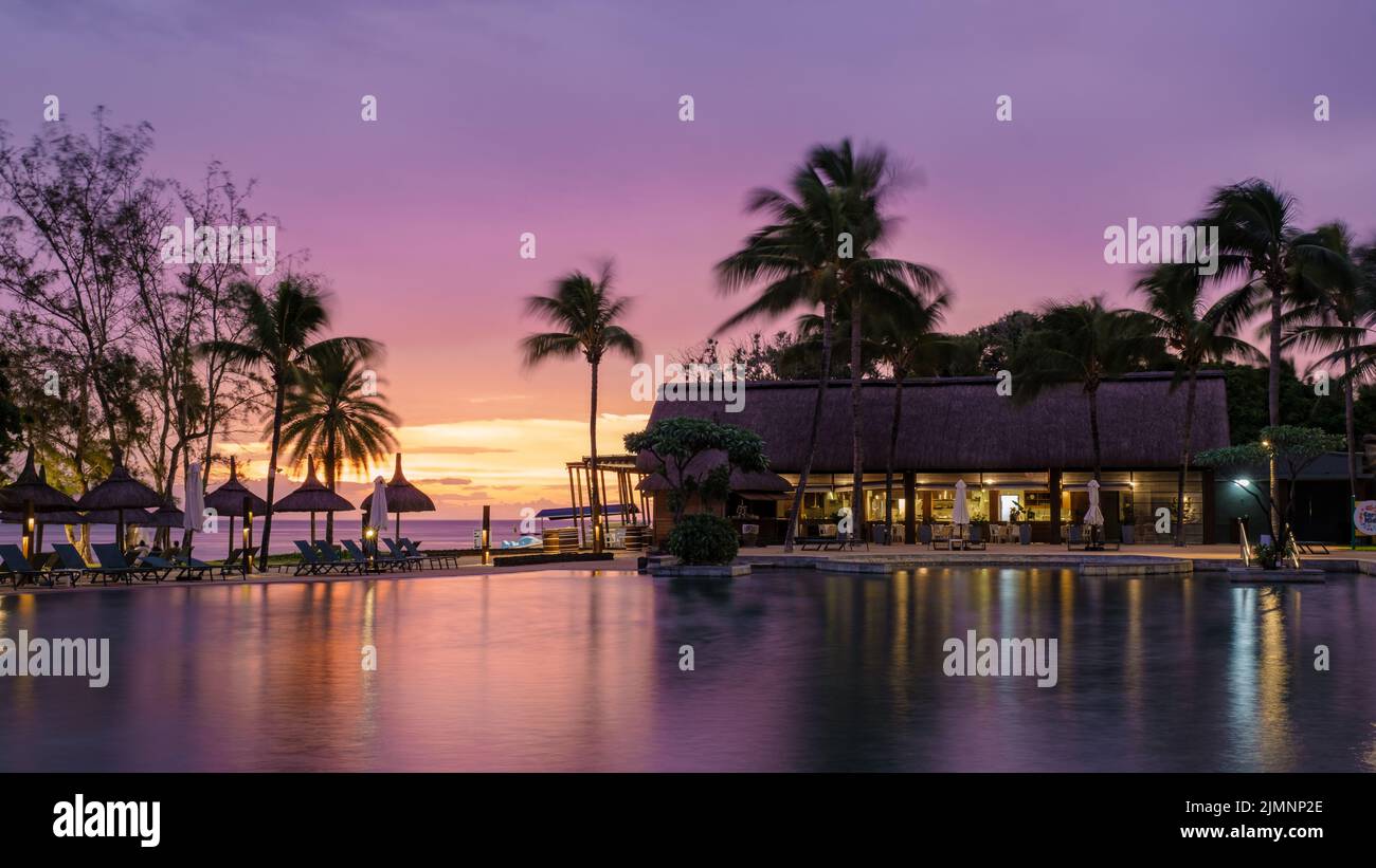 Swimming pool with beach chairs and lunch table at a luxury resort ...