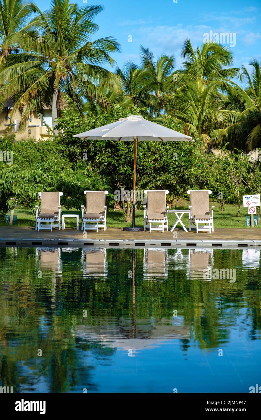 Swimming pool with beach chairs and lunch table at a luxury resort ...