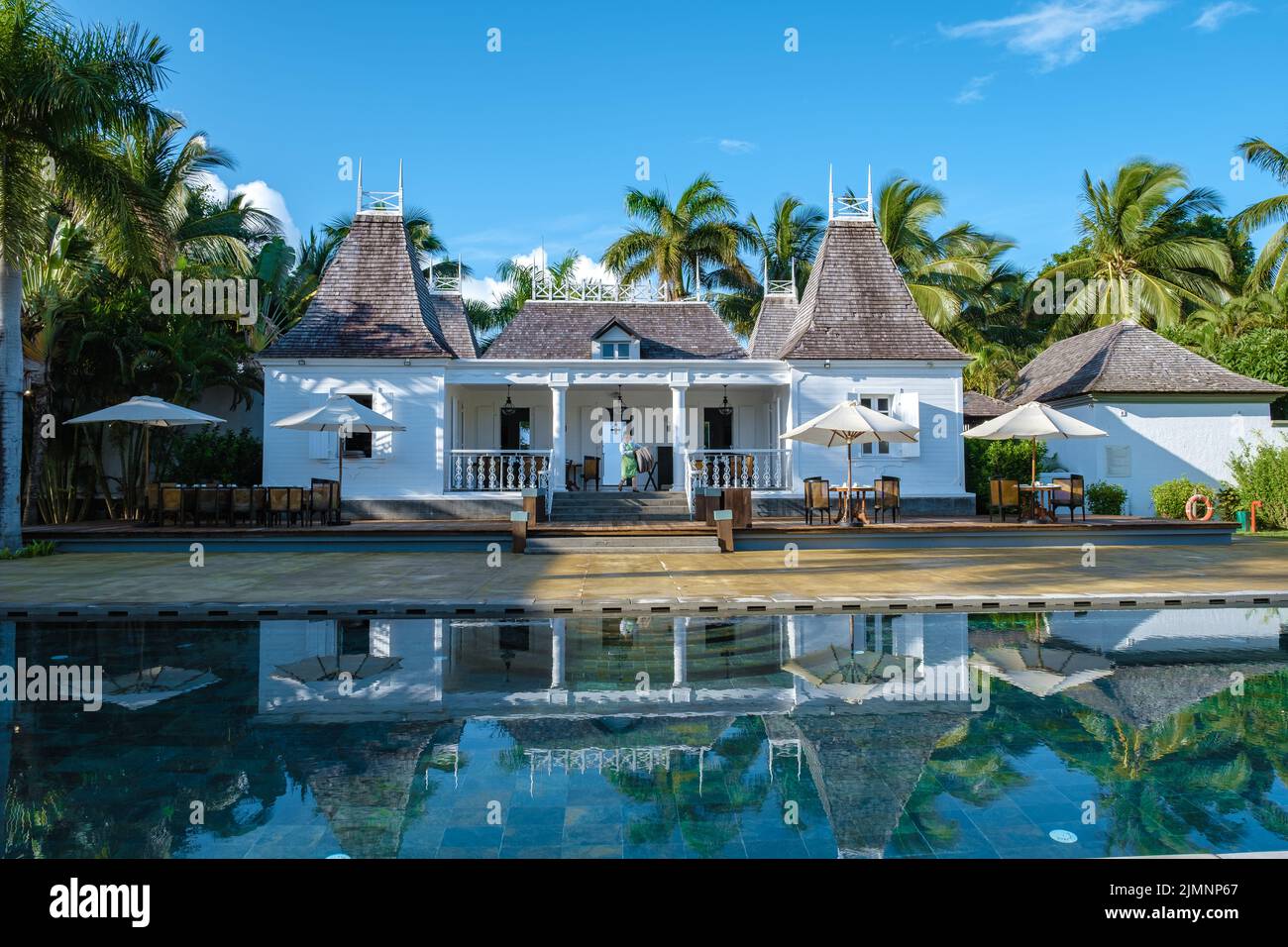 Old planttation house with swimming pool and beach chairs by the ocean ...
