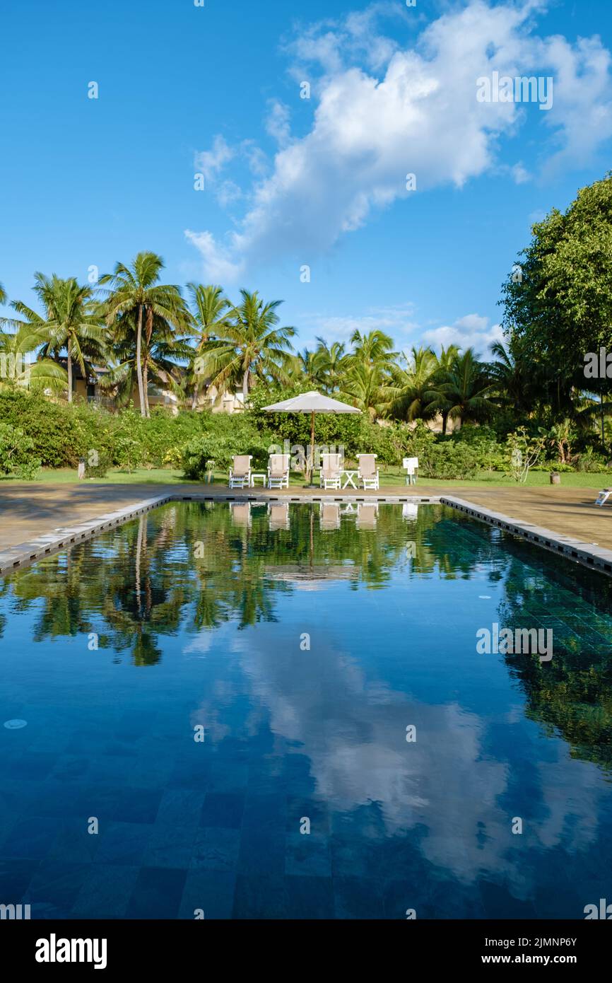 Swimming pool with beach chairs and lunch table at a luxury resort ...