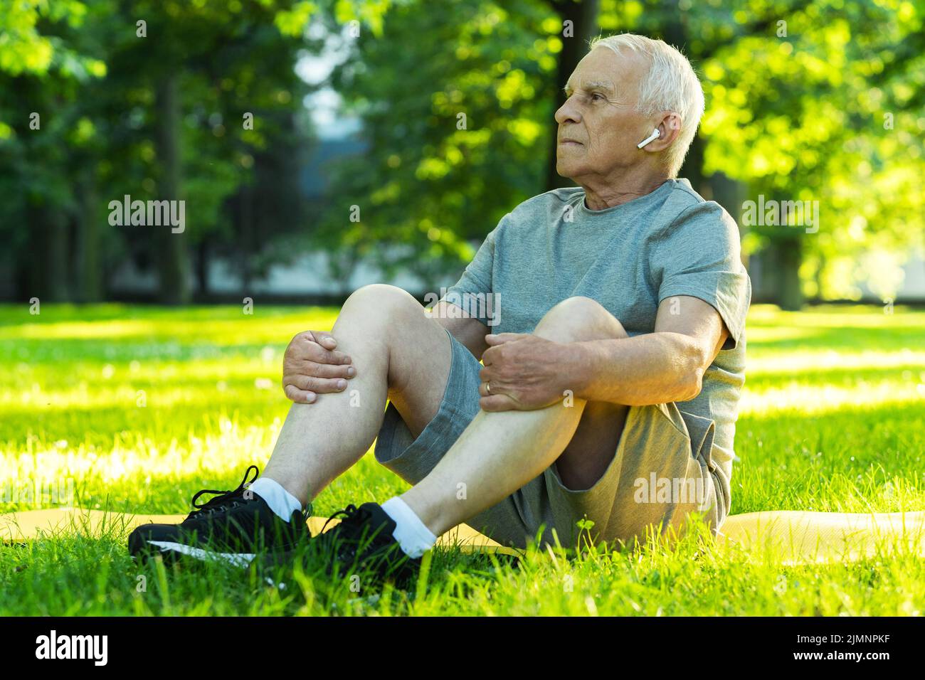 Elderly man relaxing in green city park after his workout Stock Photo ...