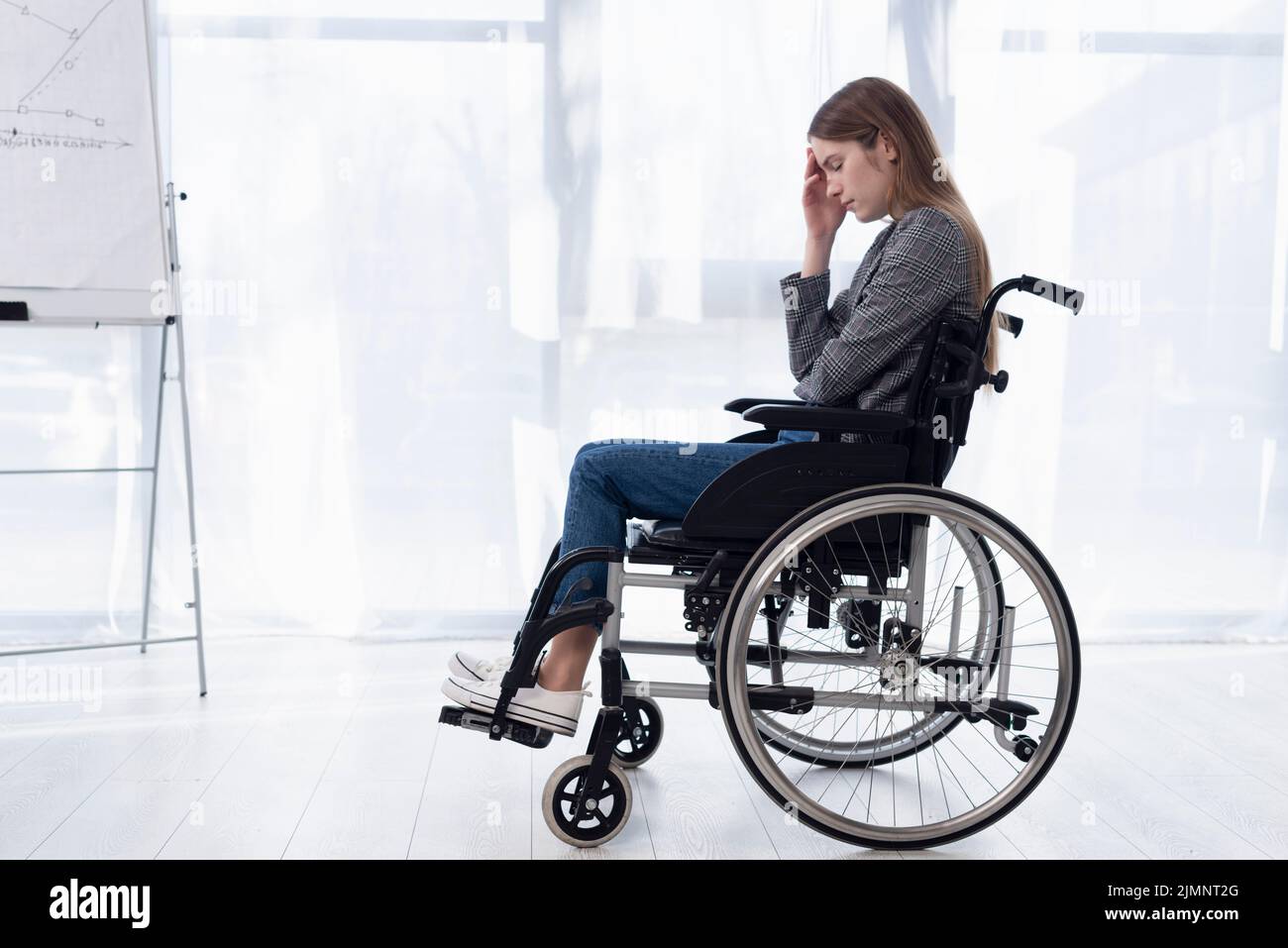 Full shot sad woman wheelchair Stock Photo - Alamy