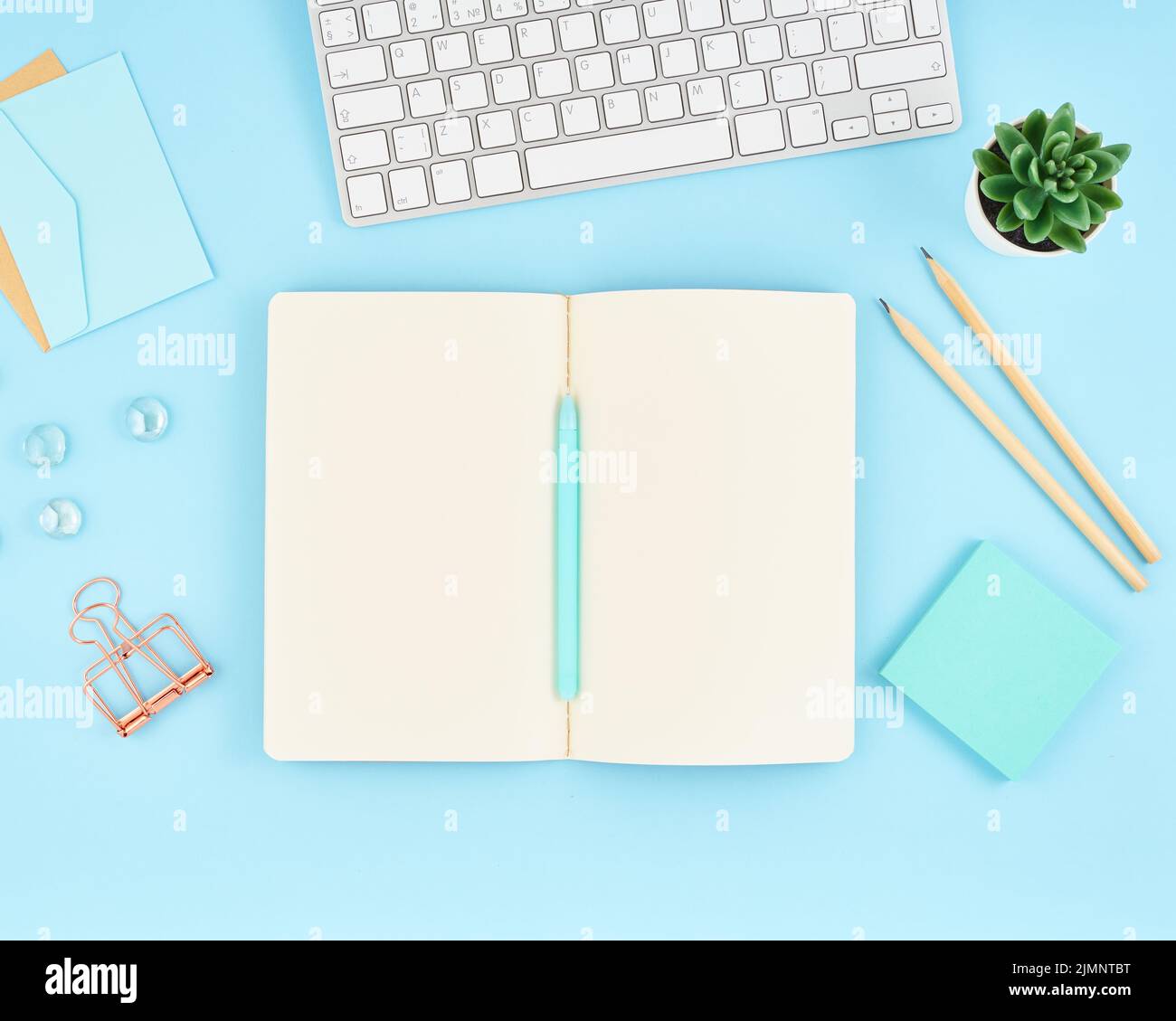 Blank notepad page for text on blue office desktop. Top view of modern ...