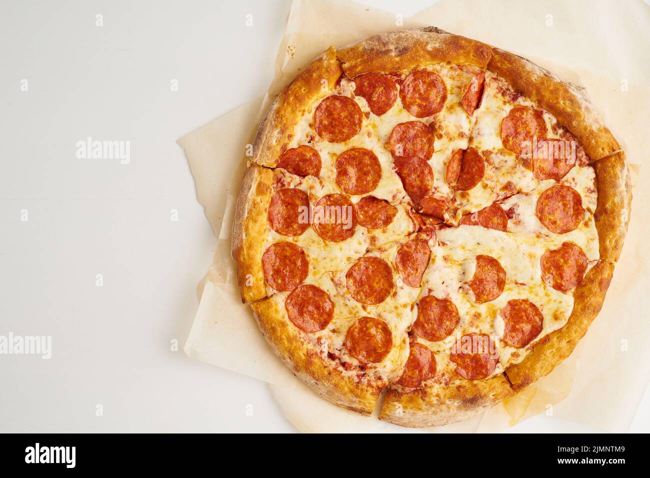 Italian pizza Pepperoni on baking paper top view Stock Photo - Alamy