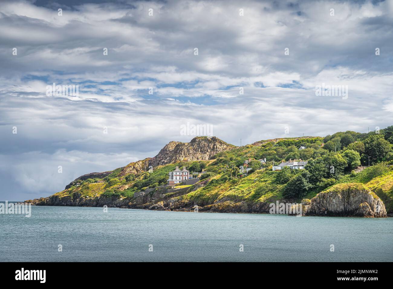 Howth cliff walk with some residential houses and lush green vegetation ...