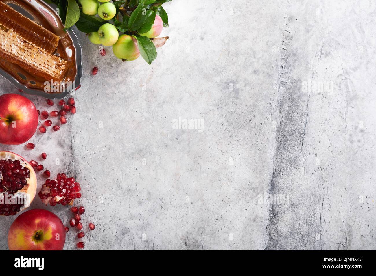 Rosh Hashanah. Honey jar, honeycomb, apple and pomegranate on gray old ...