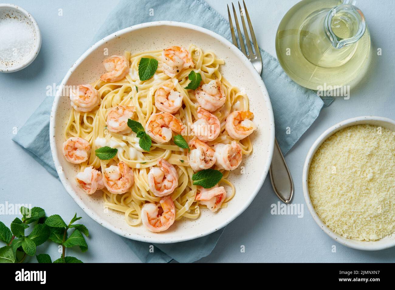 Pasta bavette with fried shrimps, bechamel sauce, mint leaf on blue ...