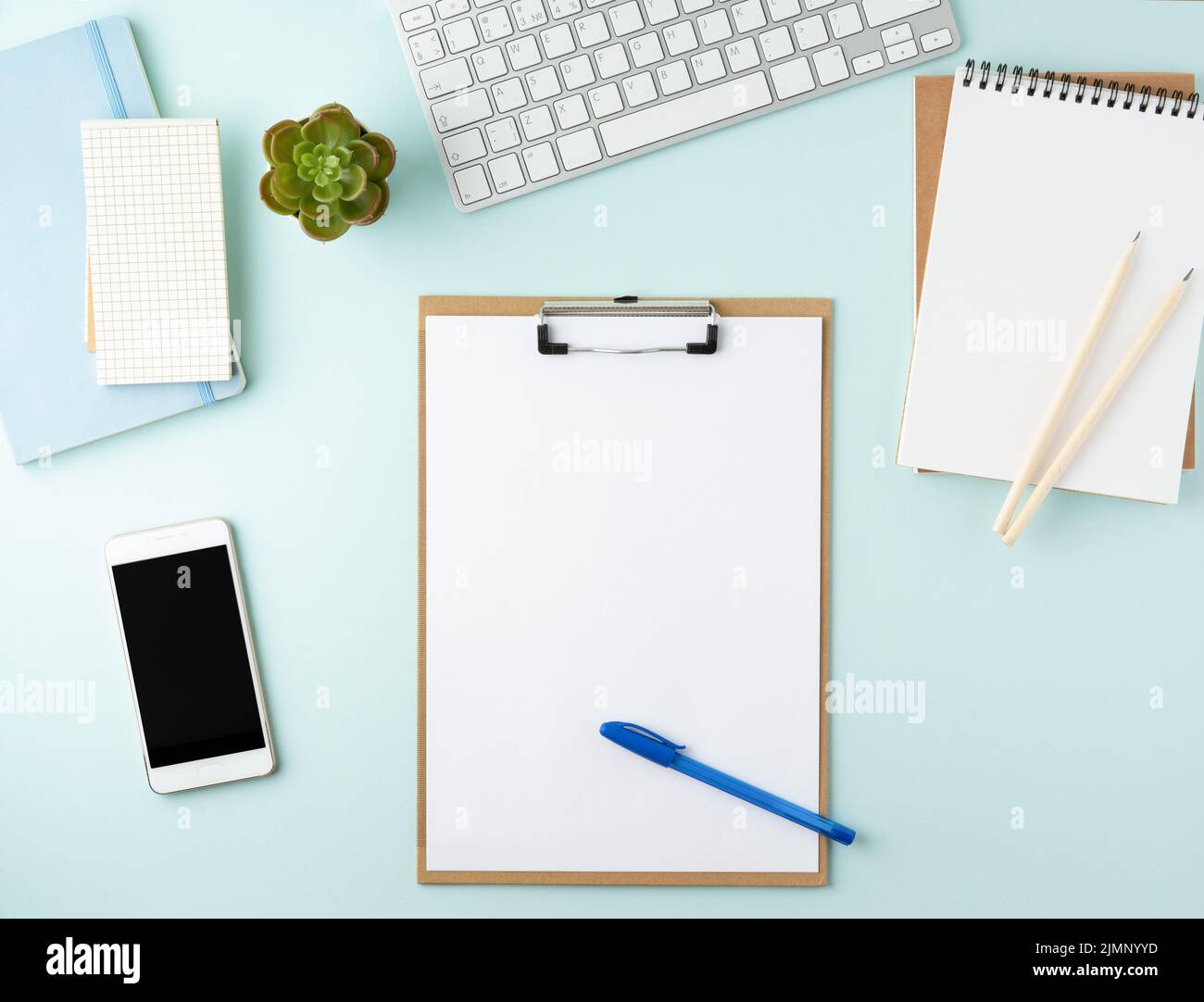 Top view of modern blue office desktop with blank notepad, computer ...