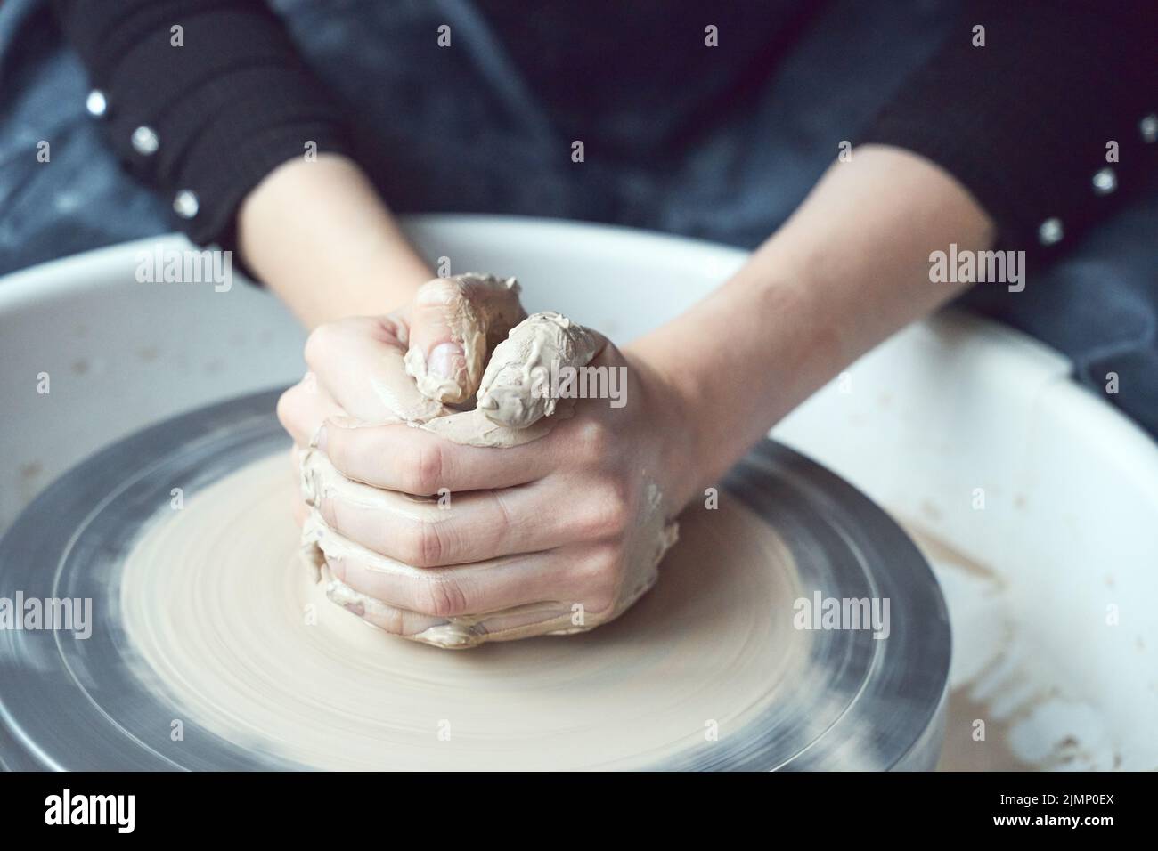 Woman making ceramic pottery on wheel, hands close-up, creation of ...
