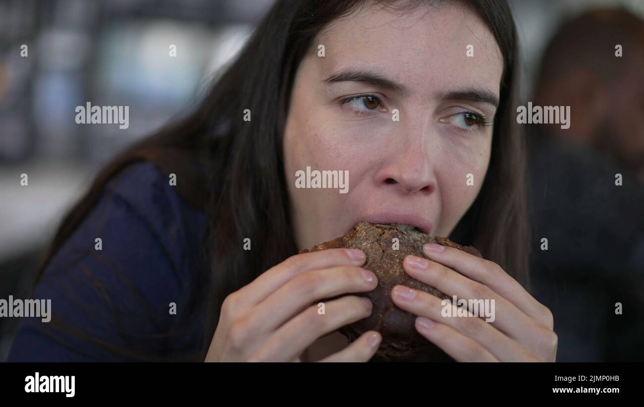 Woman eating cheeseburger closeup mouth. Person takes a bite of ...