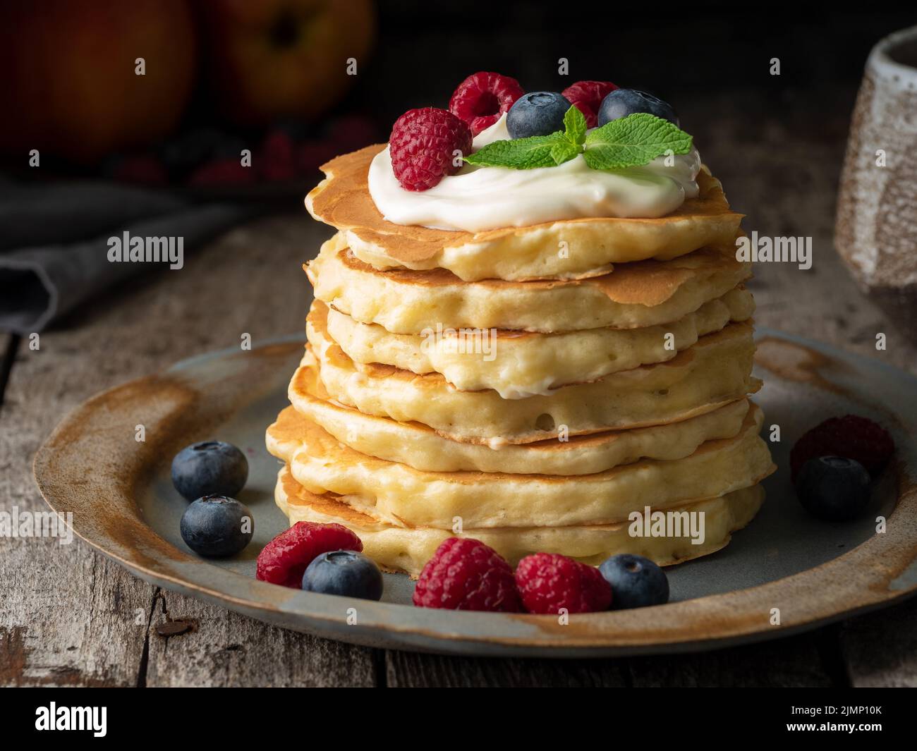 Pancake with vanilla cream, blueberries and raspberries. Side view ...