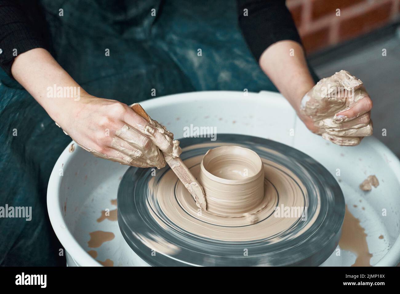 Woman making ceramic pottery on wheel, hands close-up, creation of ...