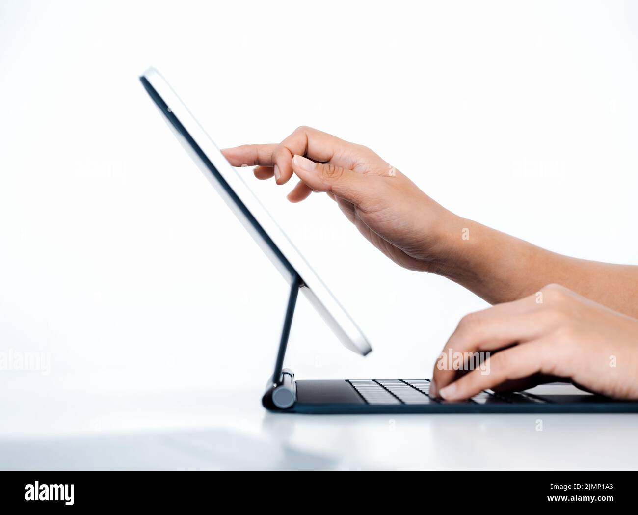 Person's finger touching, drawing on digital tablet screen while typing ...