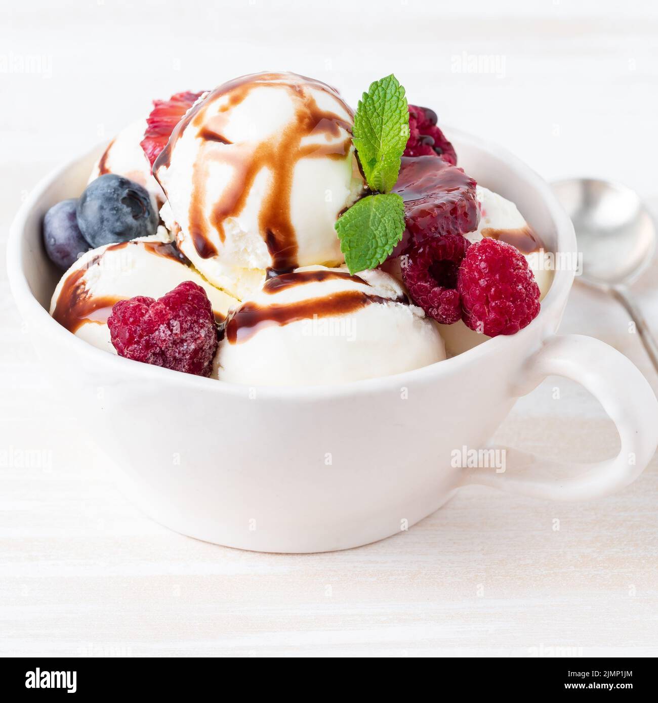 Balls of vanilla ice cream in mug with raspberry and blueberries ...