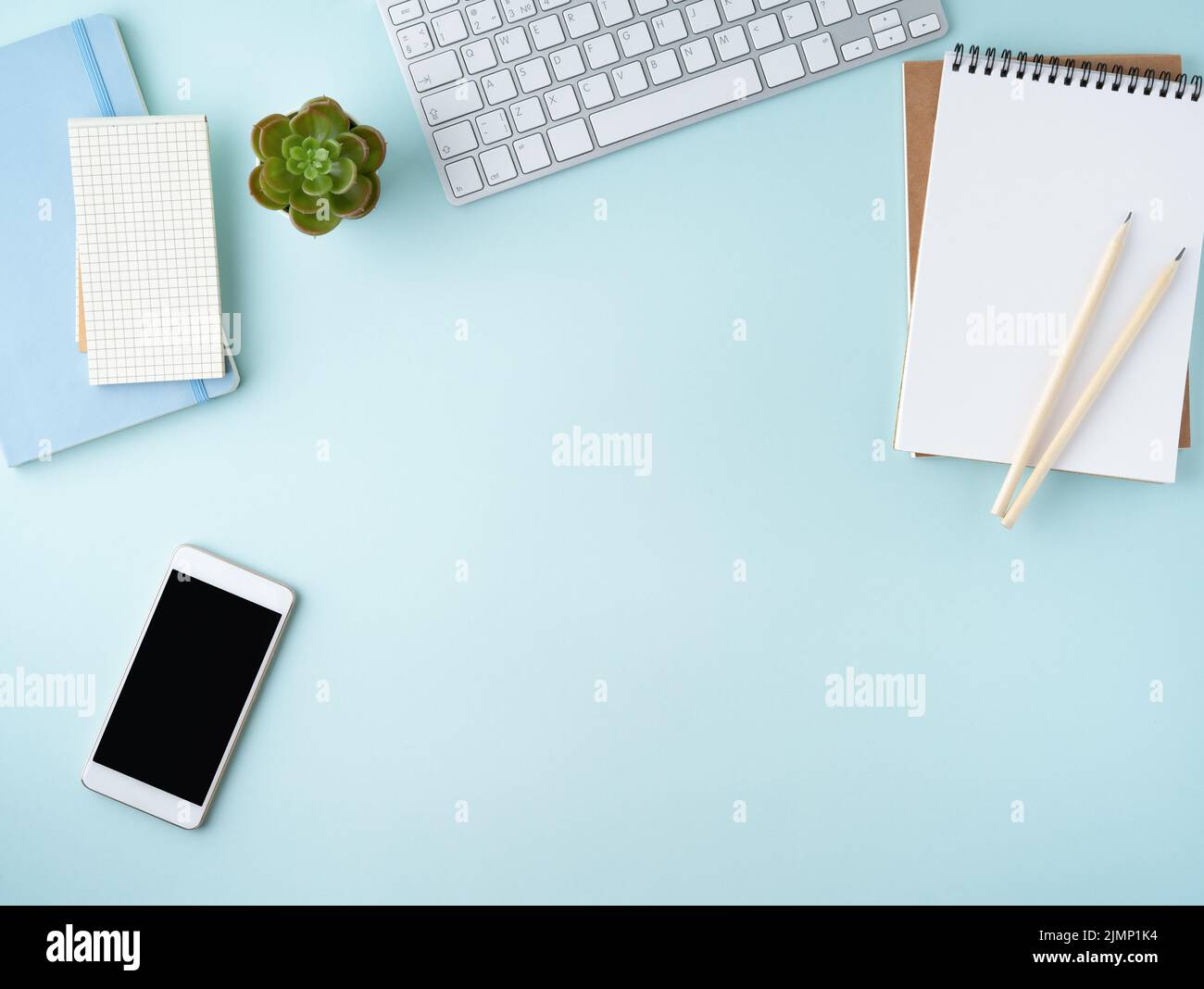Top view of modern blue office desktop with blank notepad, computer ...