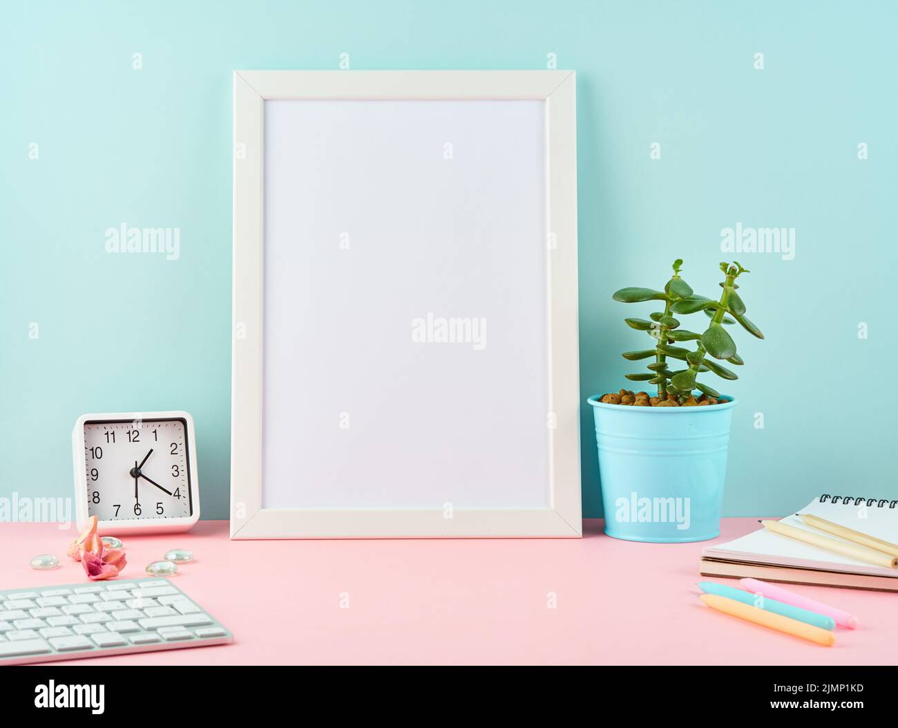 Mockup with blank white frame, alarm, notepad, cup of coffee on pink ...