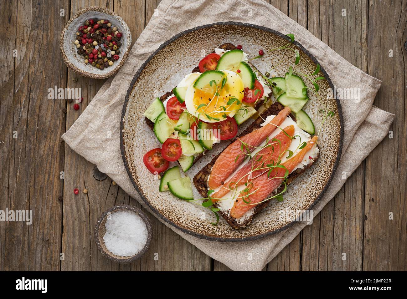 Smorrebrod - traditional Danish sandwiches. Black rye bread with salmon, cream cheese, cucumber ...