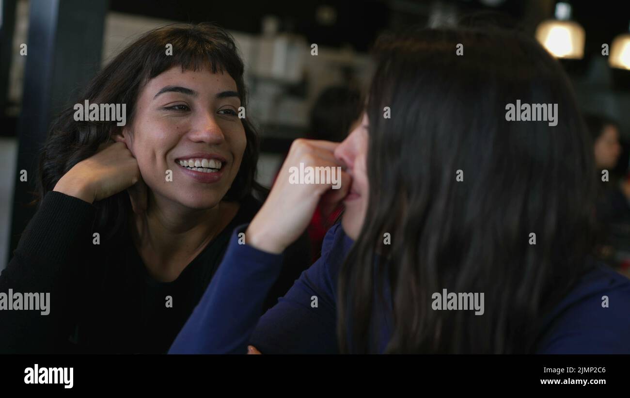 Happy women in conversation at cafe restaurant. Two people talking ...