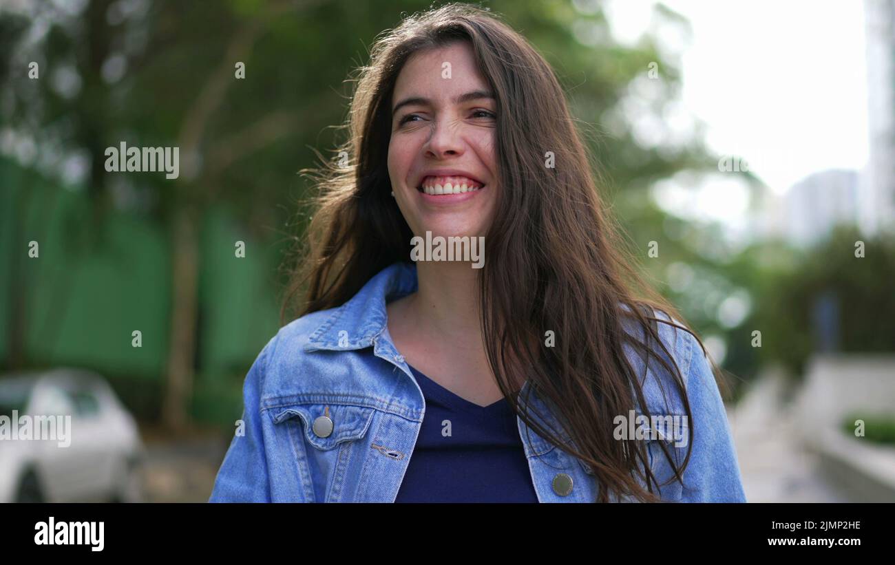 Happy young woman walking outside. A joyful expressive girl smiling ...