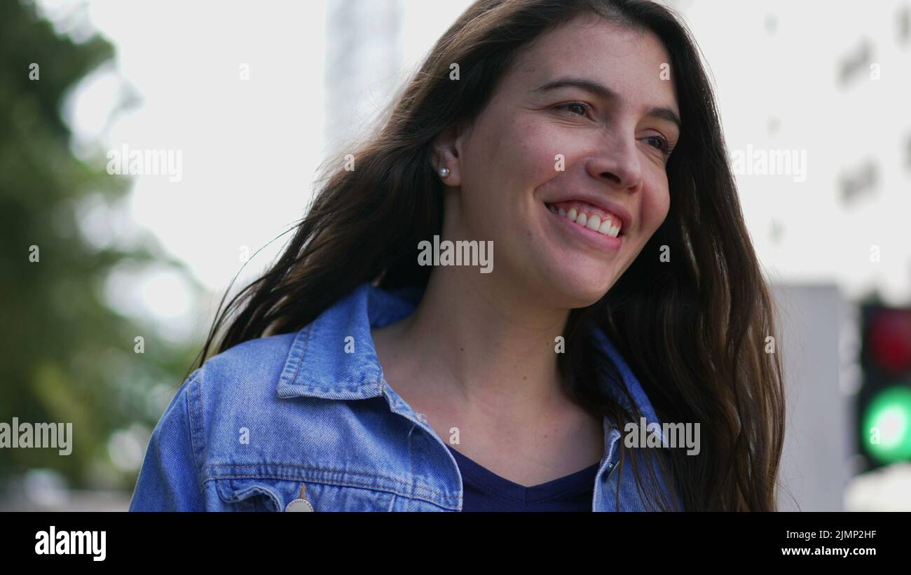 Happy young woman walking outside. A joyful expressive girl smiling ...