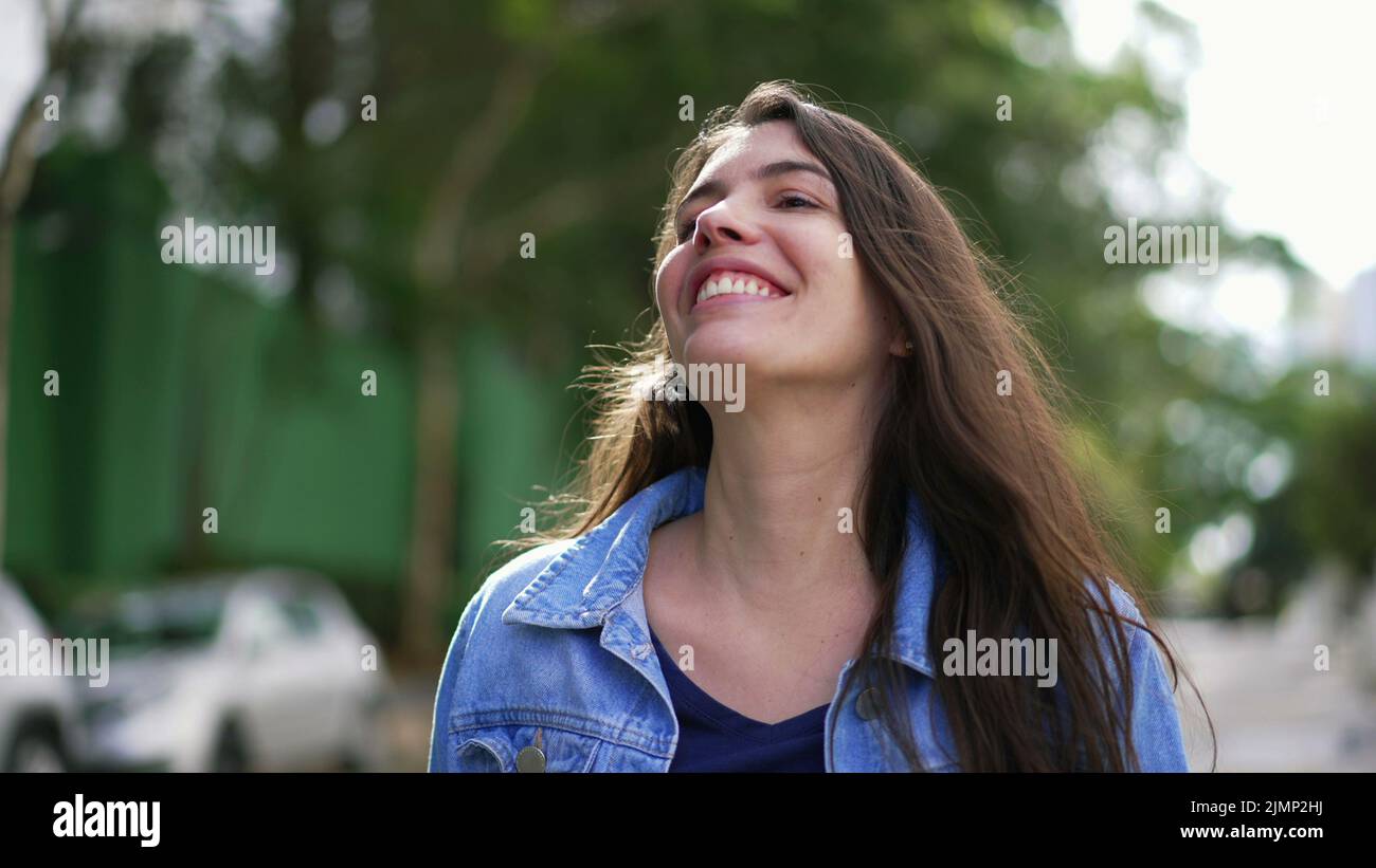 Happy young woman walking outside. A joyful expressive girl smiling ...