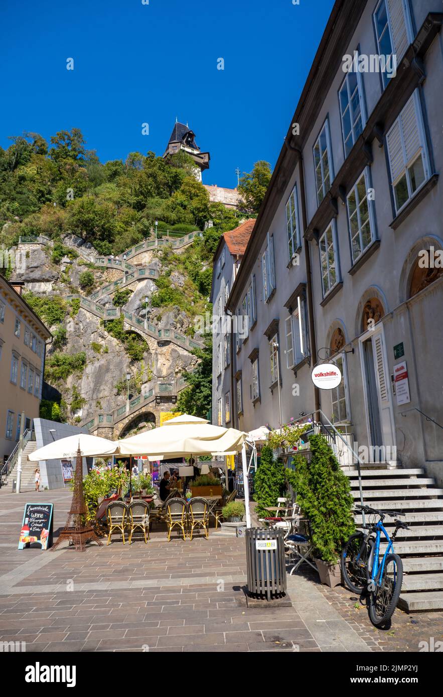 A vertical shot of restaurants and small shops by a stone hill in the ...
