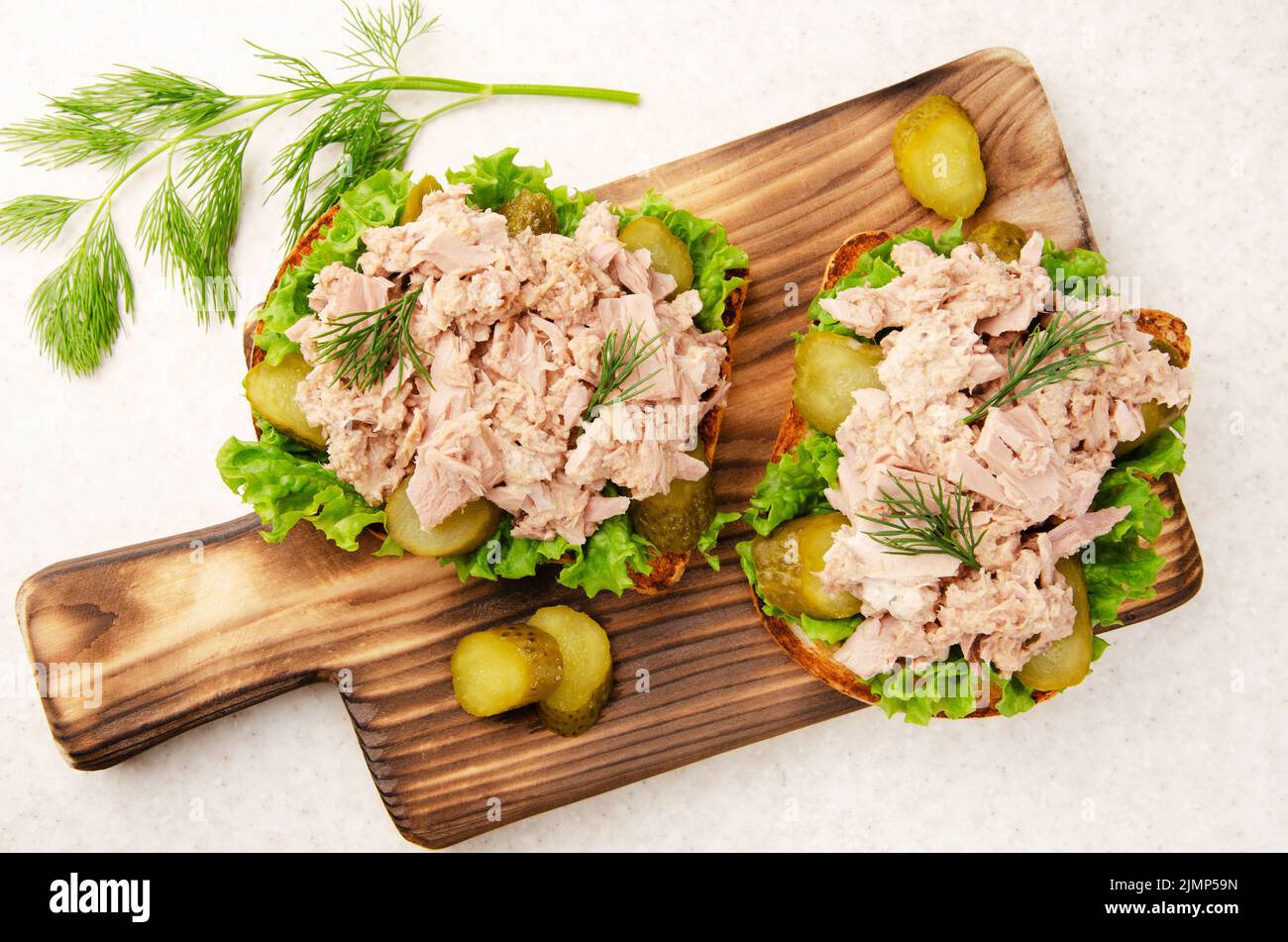 Flat lay view at homemade tuna salad sandwiches on cutting board with ...