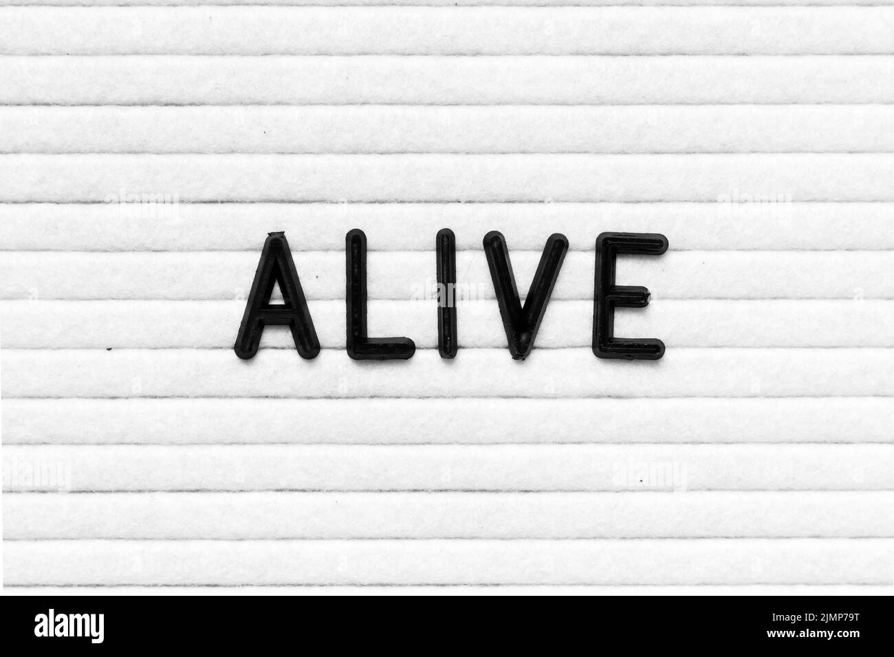 Black color letter in word alive on white felt board background Stock ...