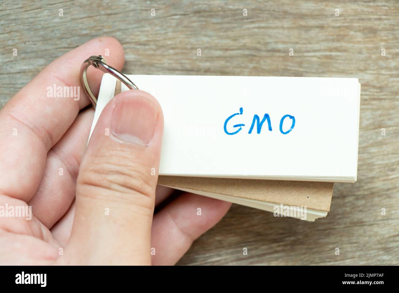 Man hold the flash card with handwriting word GMO (abbreviation of ...
