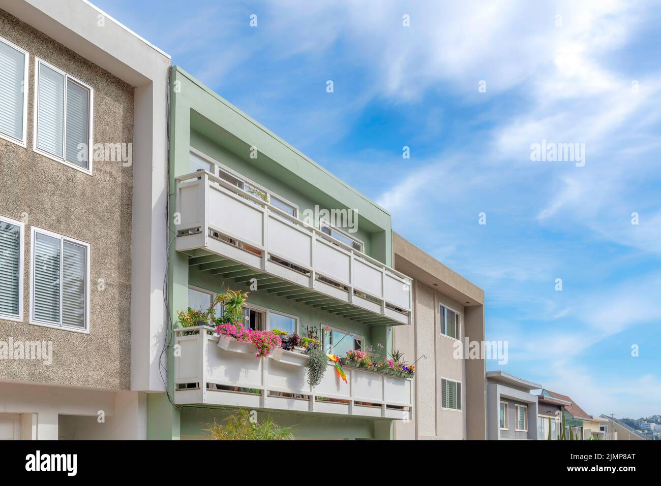 Complex box houses with a view of two balconies with white railings in ...