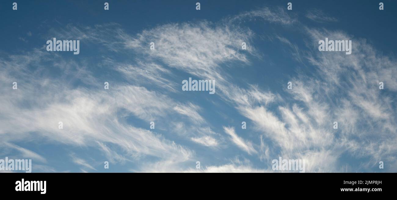 Wispy sweeping clouds across a blue sky Stock Photo - Alamy