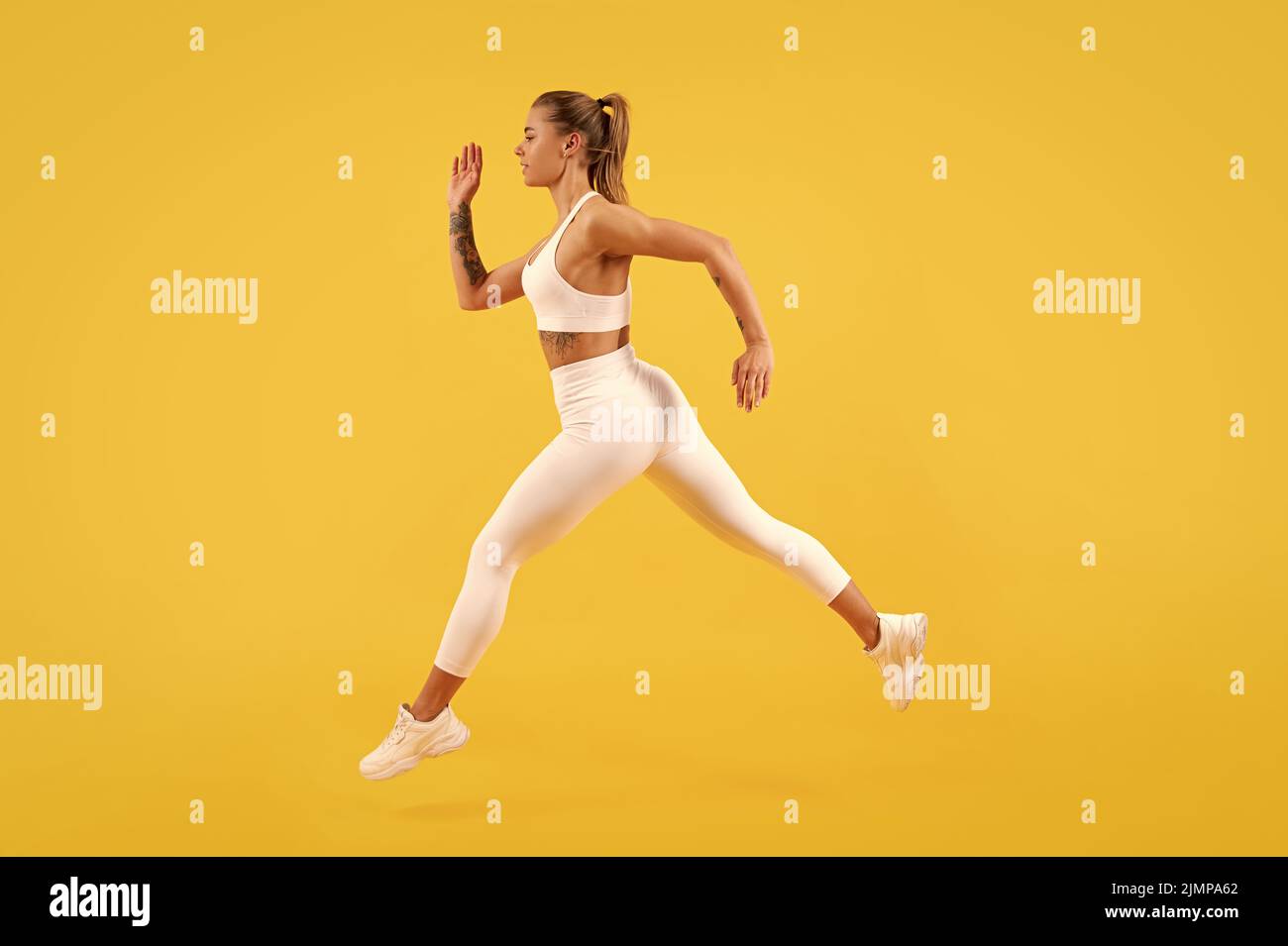 sport woman runner running on yellow background Stock Photo - Alamy