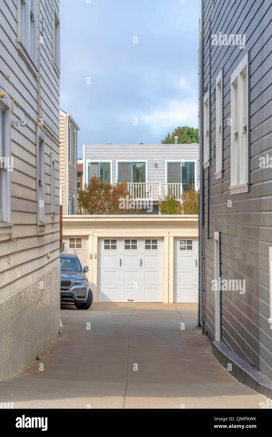 Alleyway in the middle of houses with white and black vinyl lap sidings ...