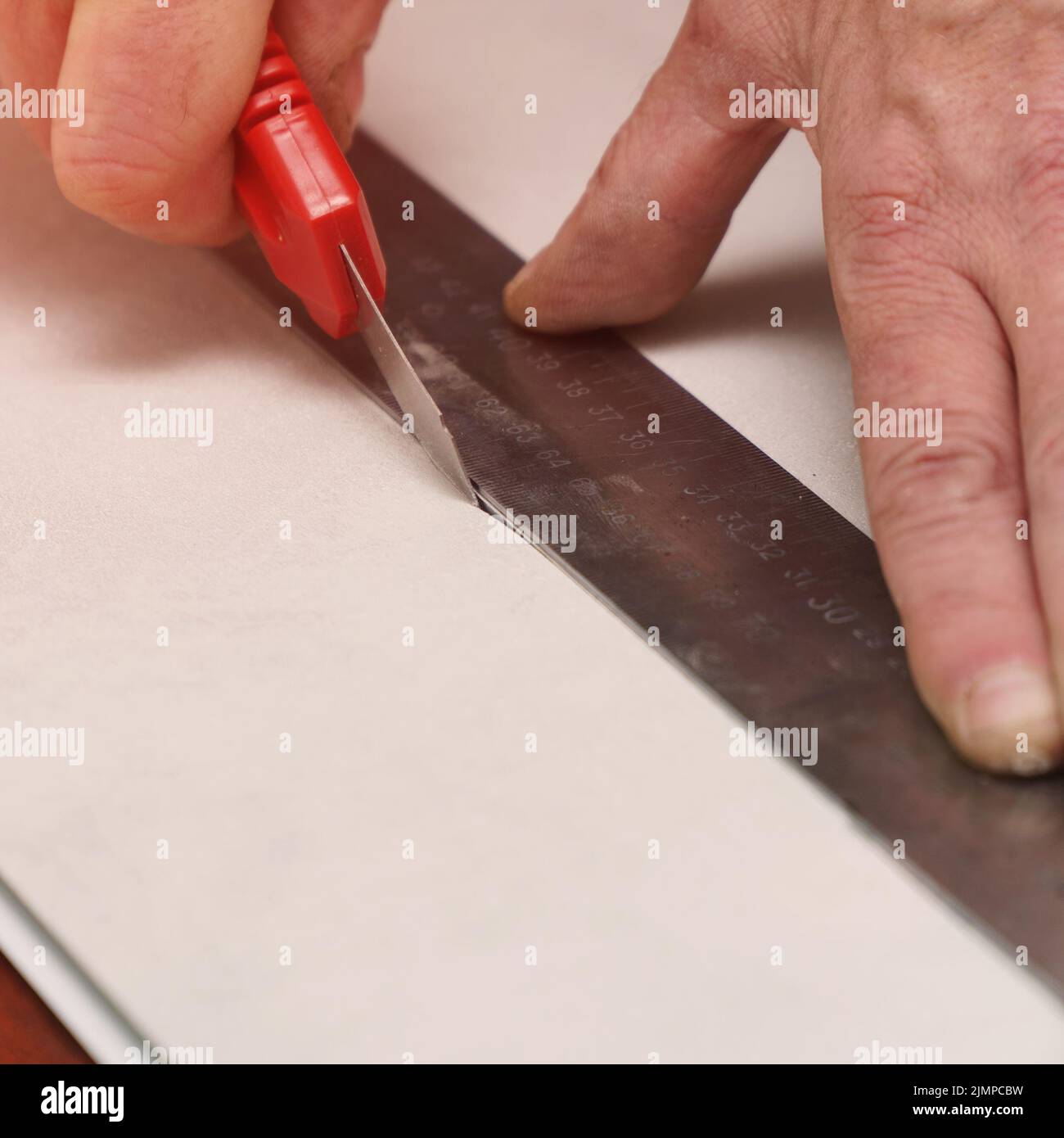 A man cuts a plastic pvc panel with a construction knife Stock Photo ...