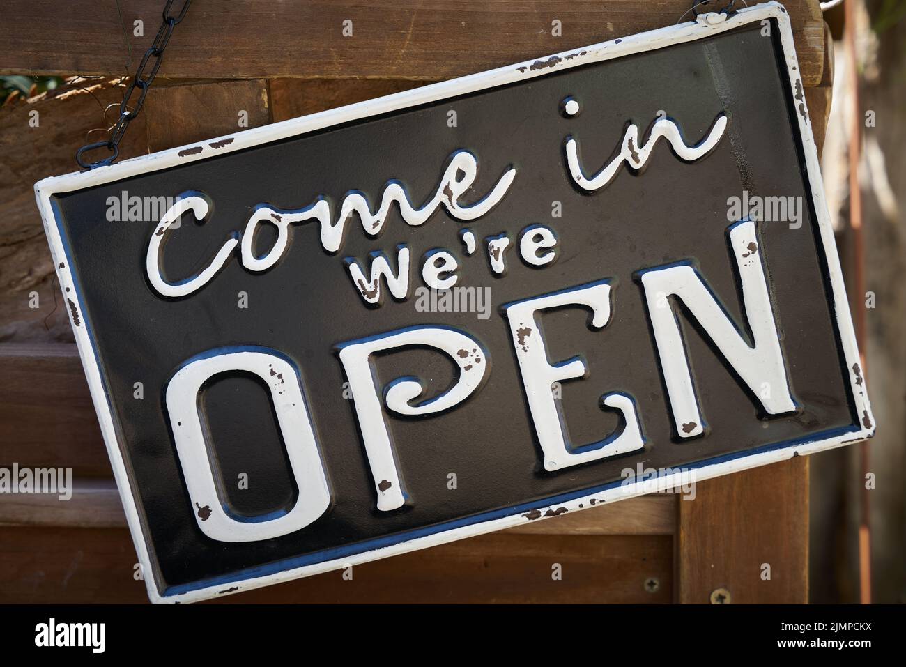 Sign on the front door of a store with the words Come in we are open ...