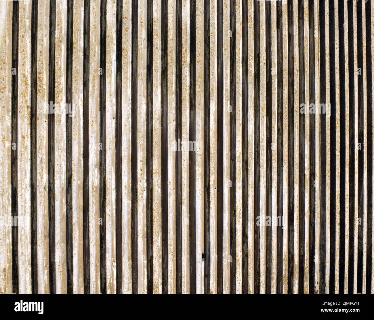 Old textured cast concrete wall with vertical lines and striped design ...