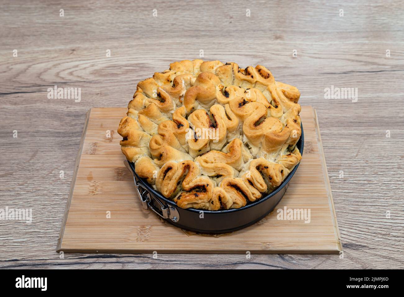 Homemade round bread with garlic butter and herbs, in a round baking ...