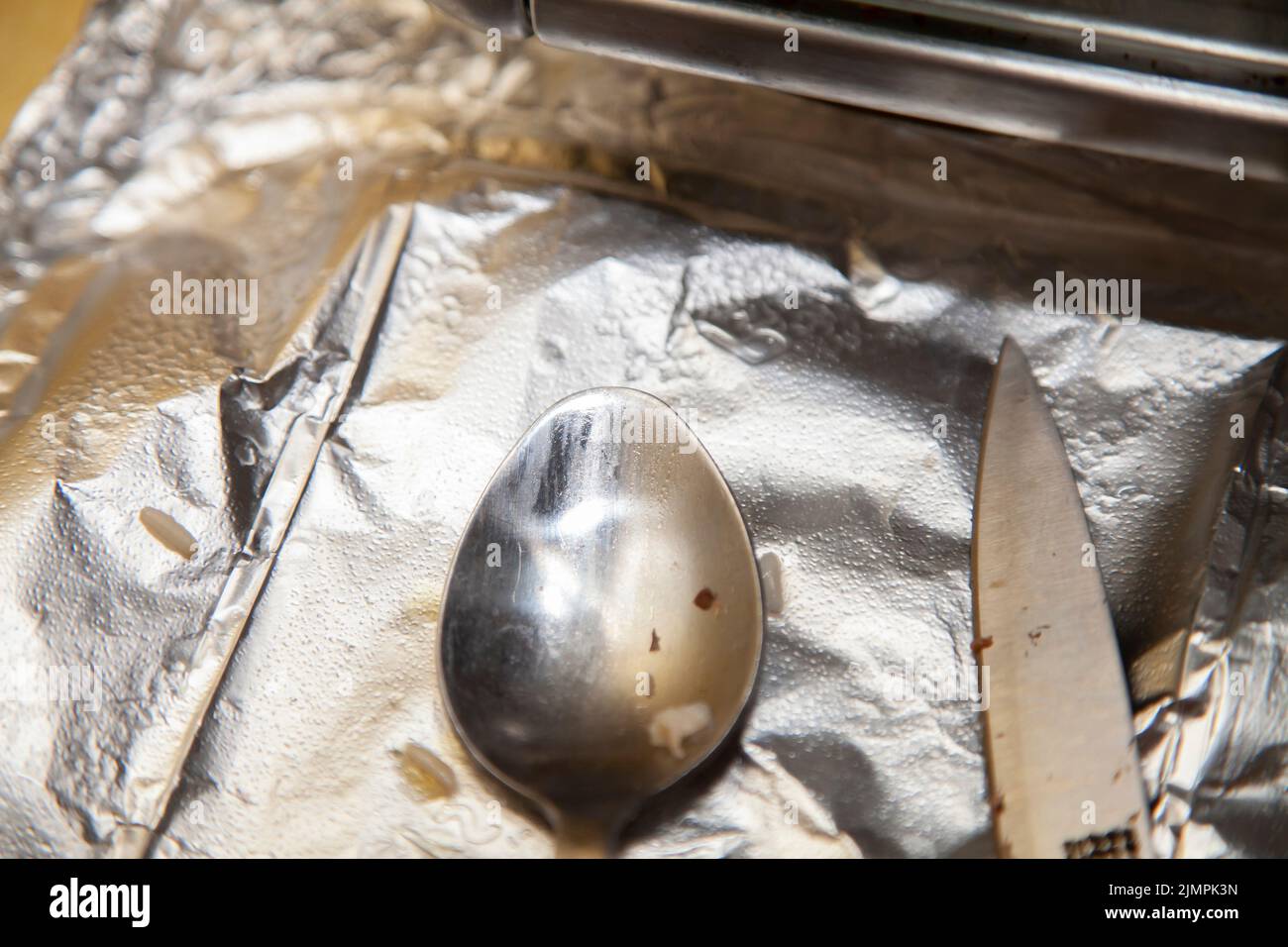 Silver spoon and sharp knife on aluminum foil Stock Photo - Alamy