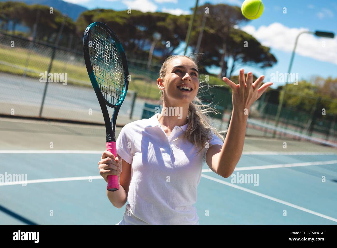 Cheerful young caucasian female player holding tennis racket while ...