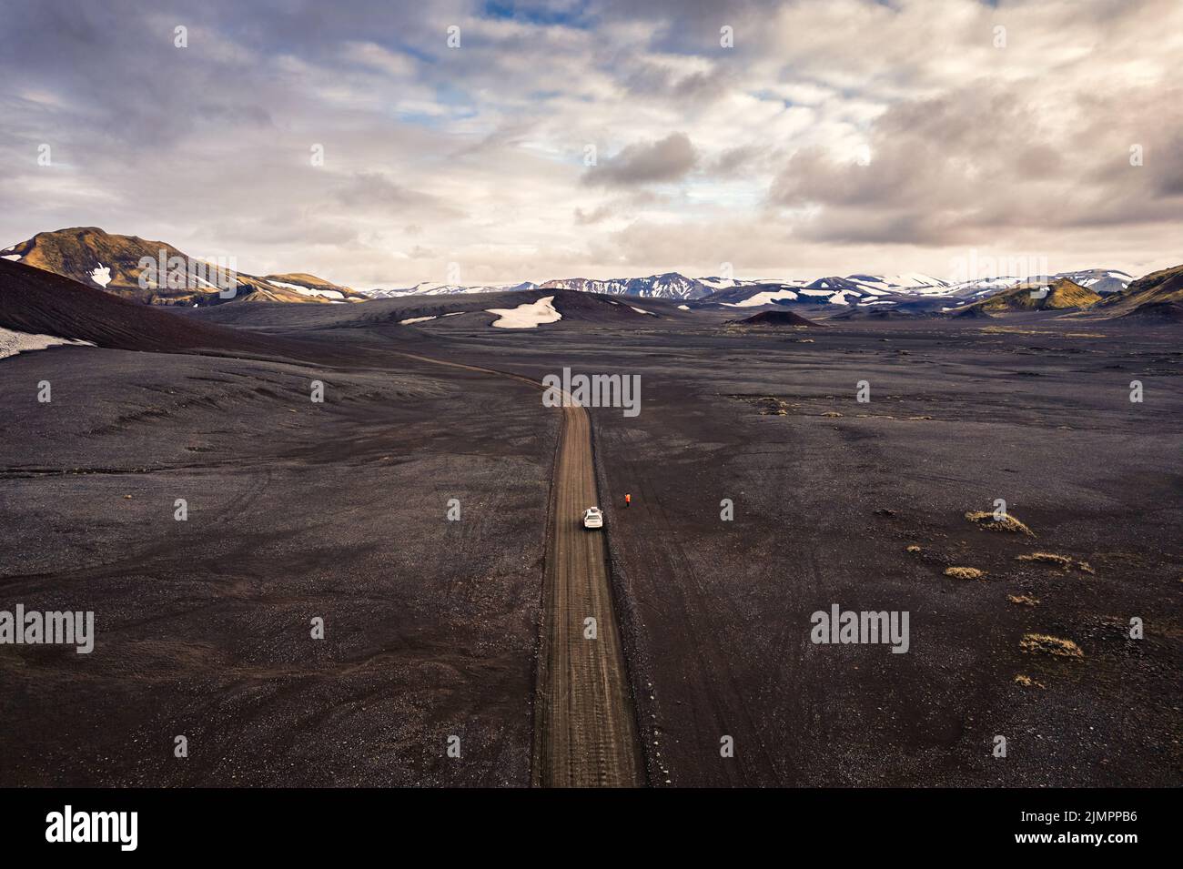 Aerial view of black volcanic desert on wilderness with 4x4 vehicle car ...