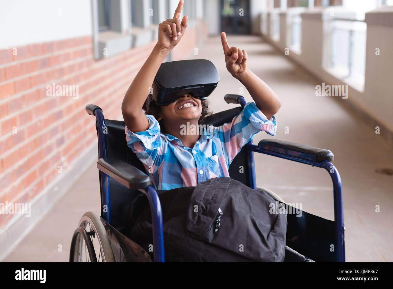 Cheerful disabled african american elementary schoolboy gesturing while ...