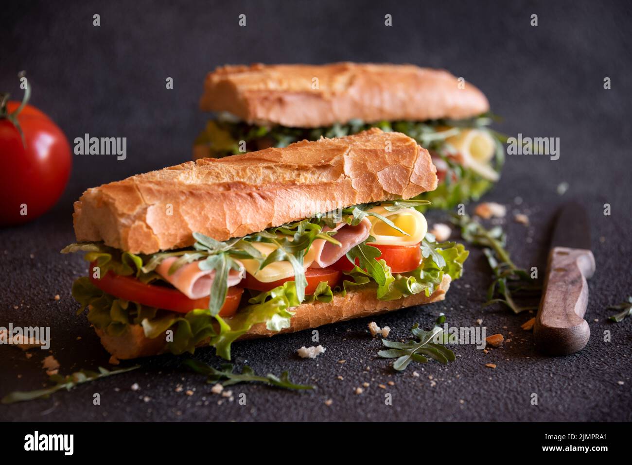 Baguette sandwich with cheese, ham, tomatoes and vegetables Stock Photo ...