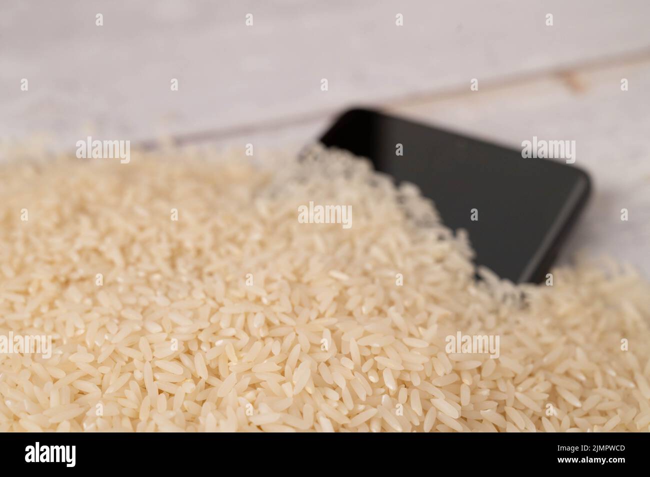 A close-up of a mobile phone placed to dry in a pile of rice after the ...